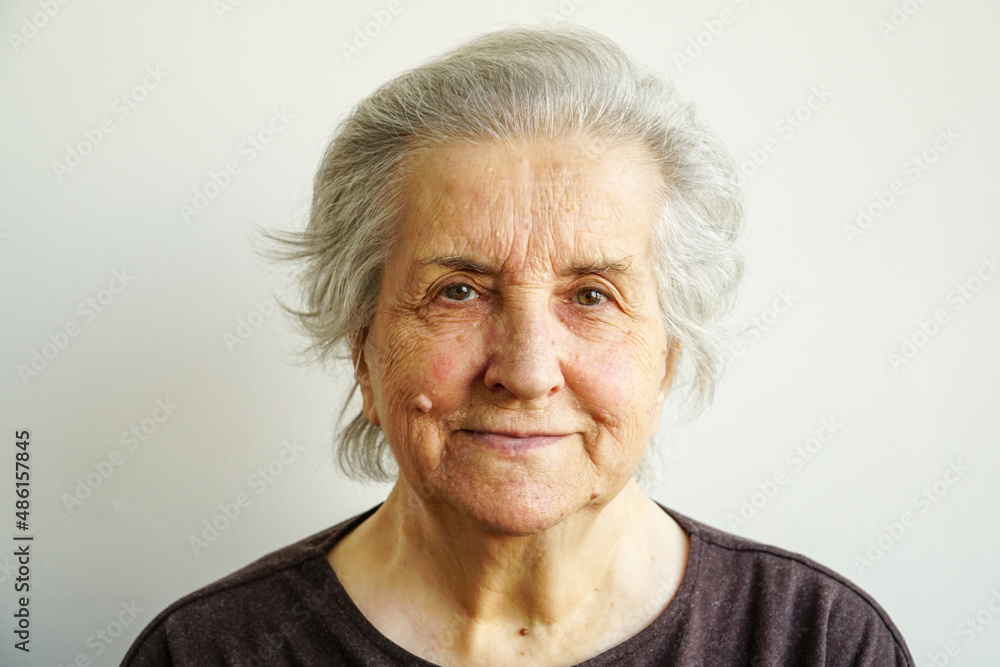Portrait of old smiling woman in seventies. Old woman with green eyes ...