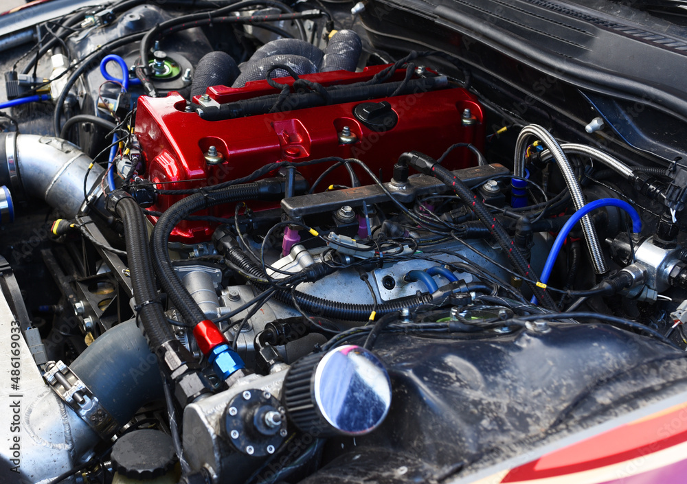 Sports car engine with turbine. An open race car hood on a pit stop ...