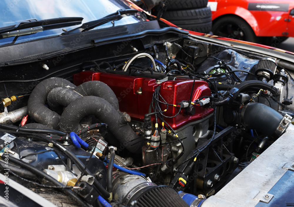 Sports car engine with turbine. An open race car hood on a pit stop ...