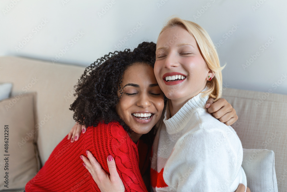 Candid diverse girls best friends embracing standing indoors, close up ...