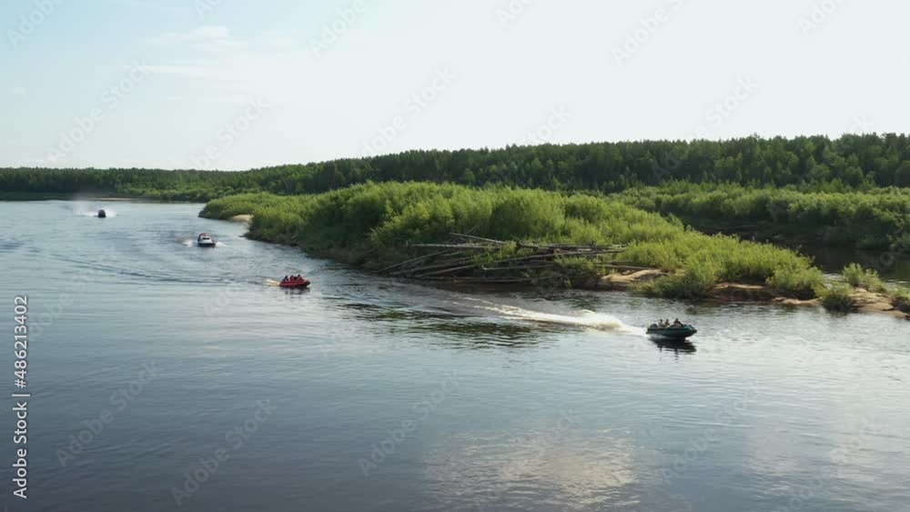 Boats sail along a beautiful river among the Siberian taiga. The ...