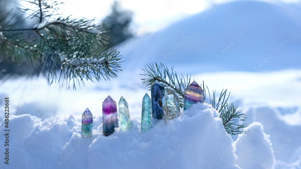 Crystals gemstones and pine branch on snow, natural winter background ...