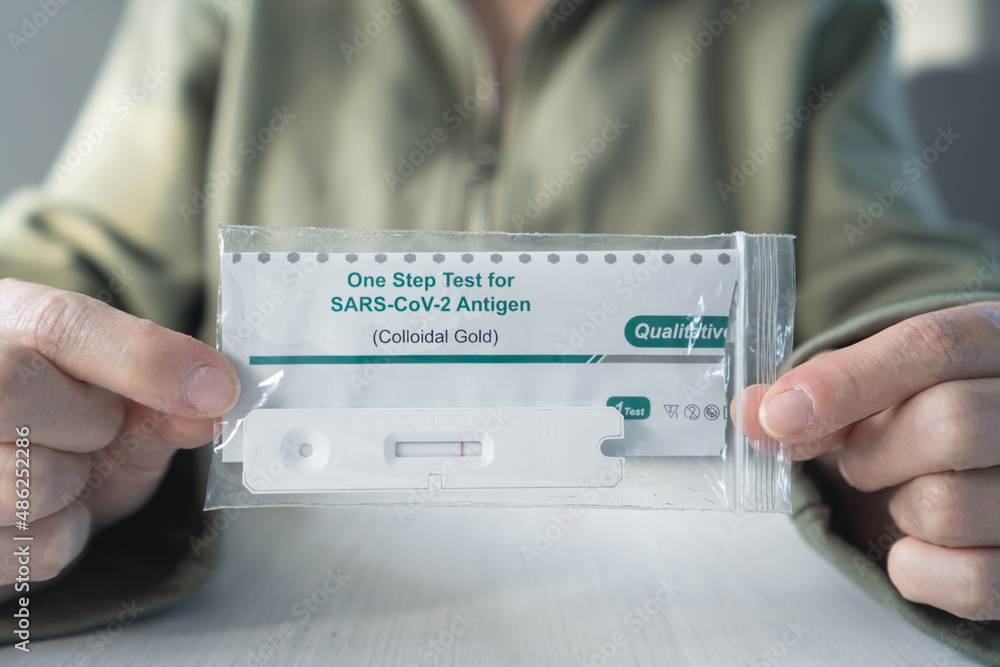 Person holding Sars cov 2 antigen home kit test card in a plastic bag ...