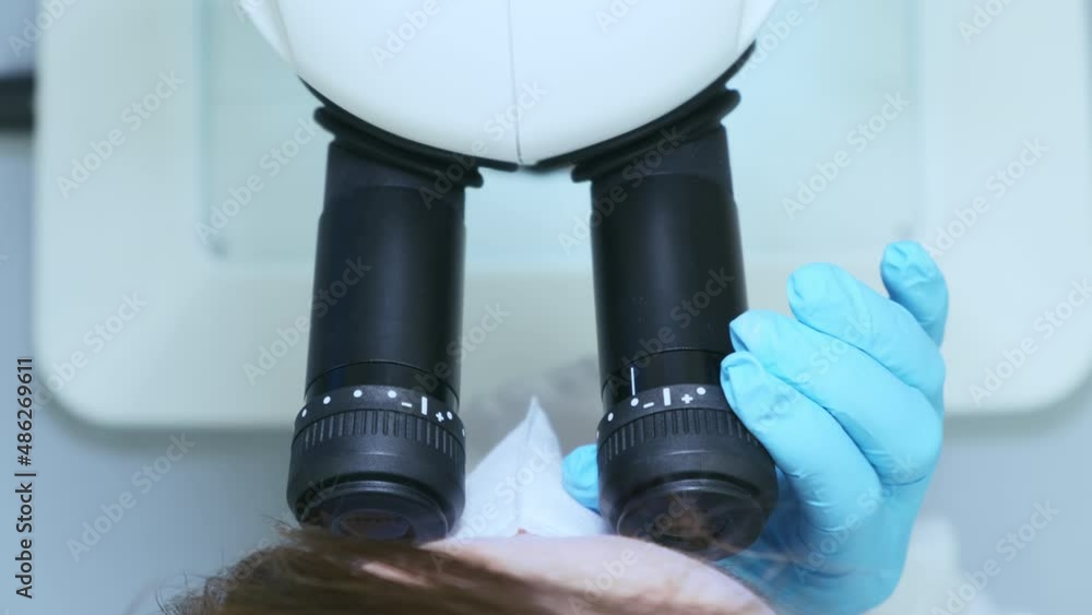 Top view of young scientist looking through a microscope in a ...