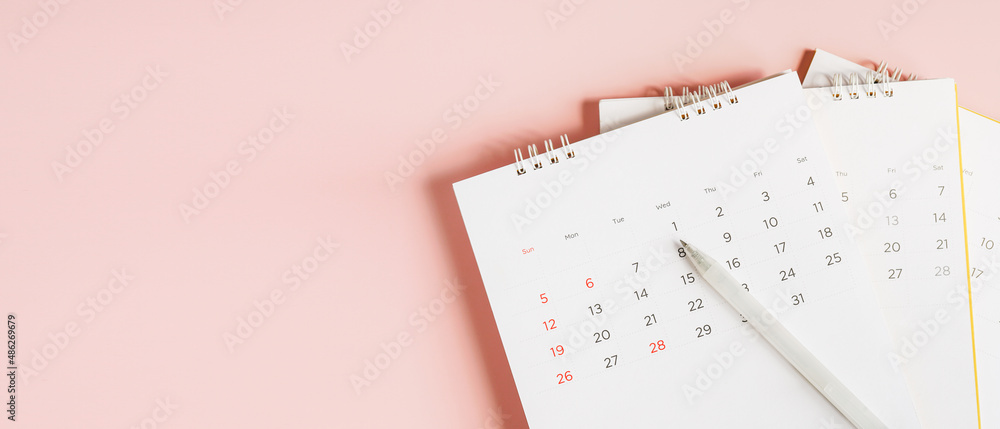 white open calendar and pen on sweet pink background, top view, for ...