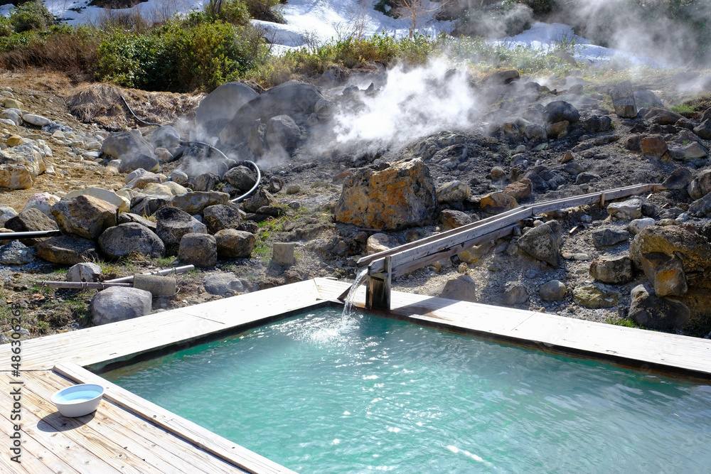 Wooden pipe line along pathway from mountain to natural onsen outdoor ...