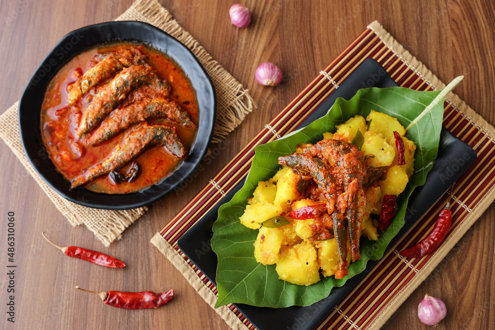 tapioca and spicy hot Kerala fish curry Indian food on banana leaf ...