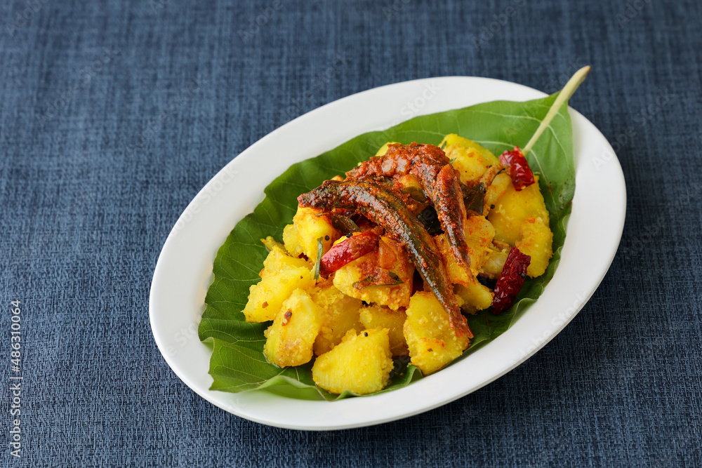 tapioca and spicy hot Kerala fish curry Indian food on banana leaf ...
