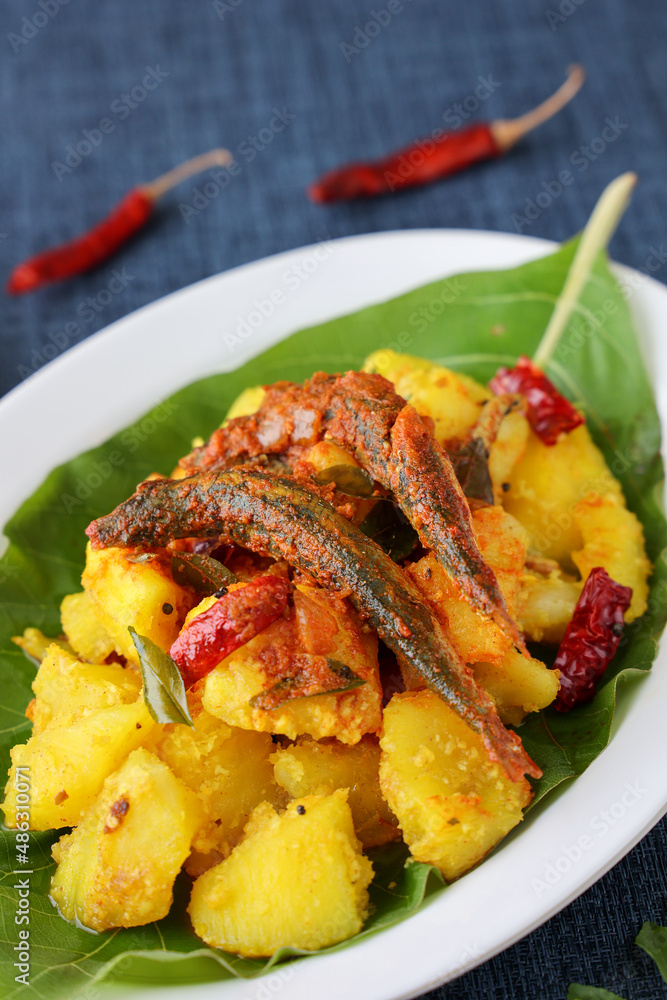tapioca and spicy hot Kerala fish curry Indian food on banana leaf ...