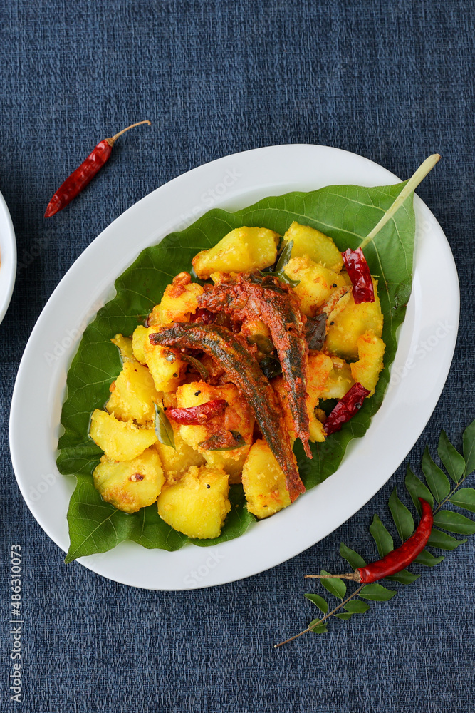 tapioca and spicy hot Kerala fish curry Indian food on banana leaf ...