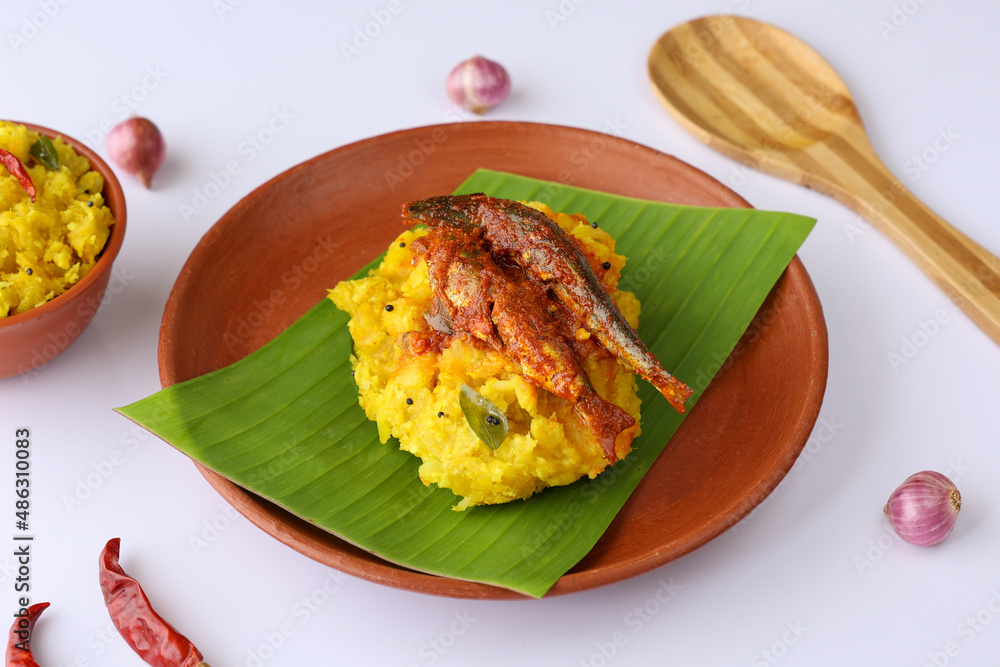tapioca and spicy hot Kerala fish curry Indian food on banana leaf ...