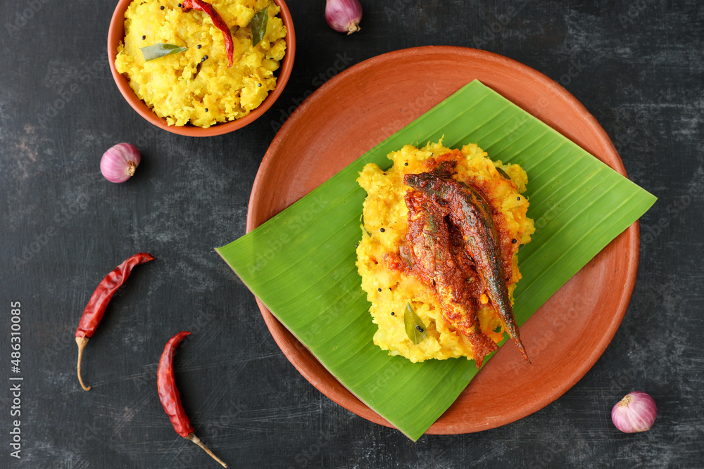 tapioca and spicy hot Kerala fish curry Indian food on banana leaf ...
