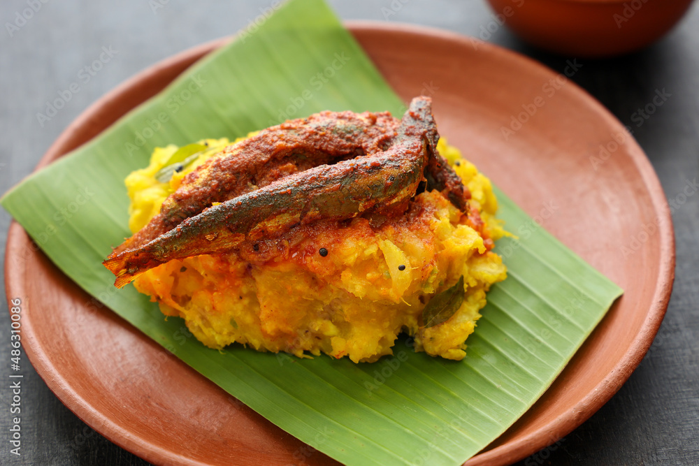 tapioca and spicy hot Kerala fish curry Indian food on banana leaf ...