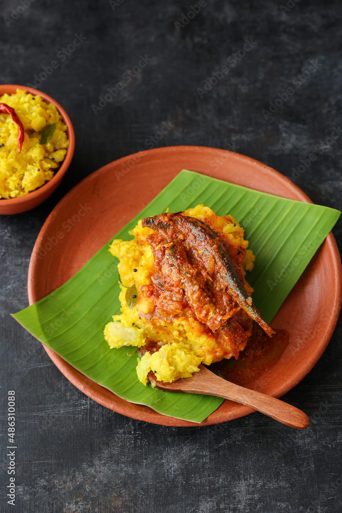 tapioca and spicy hot Kerala fish curry Indian food on banana leaf ...