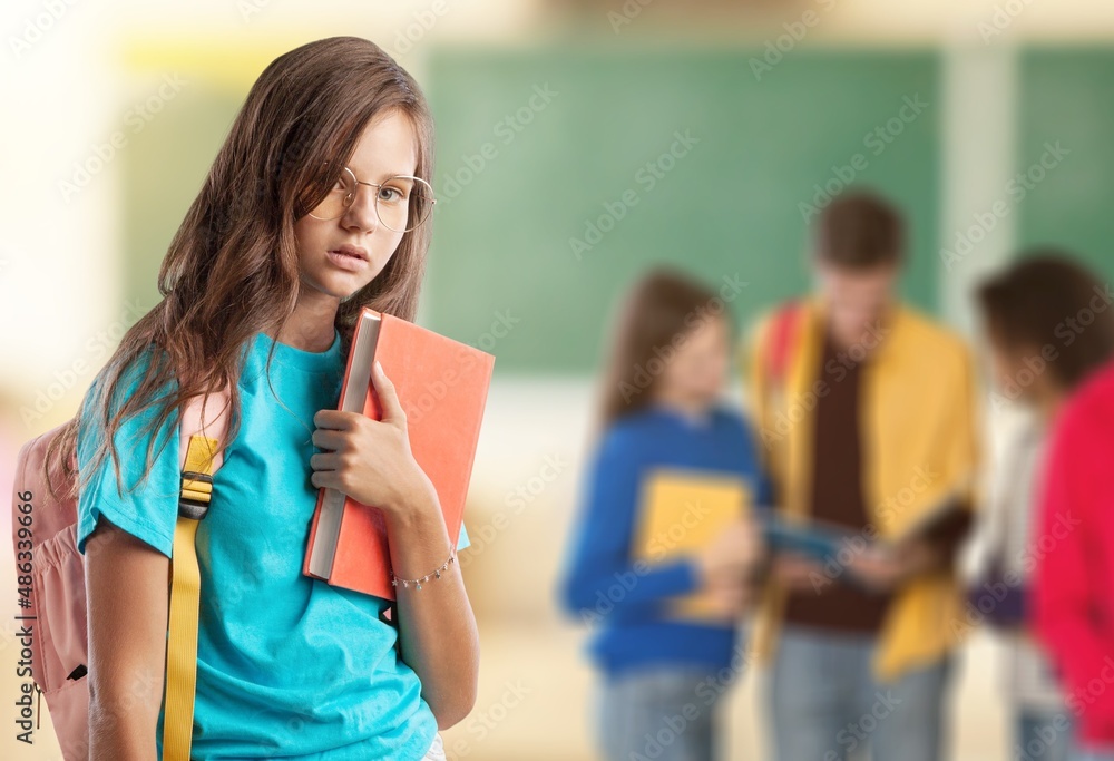 Lonely sad schoolgirl while all her classmates ignored her. Social ...