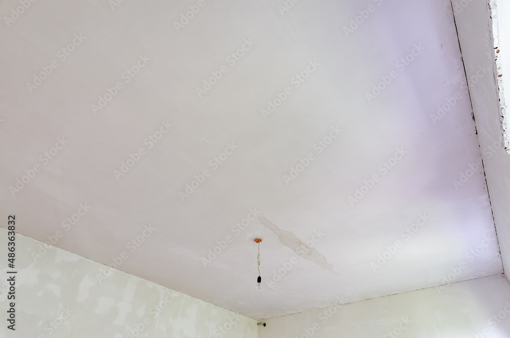 Plastered ceiling in the room, stains from flooding from above are ...