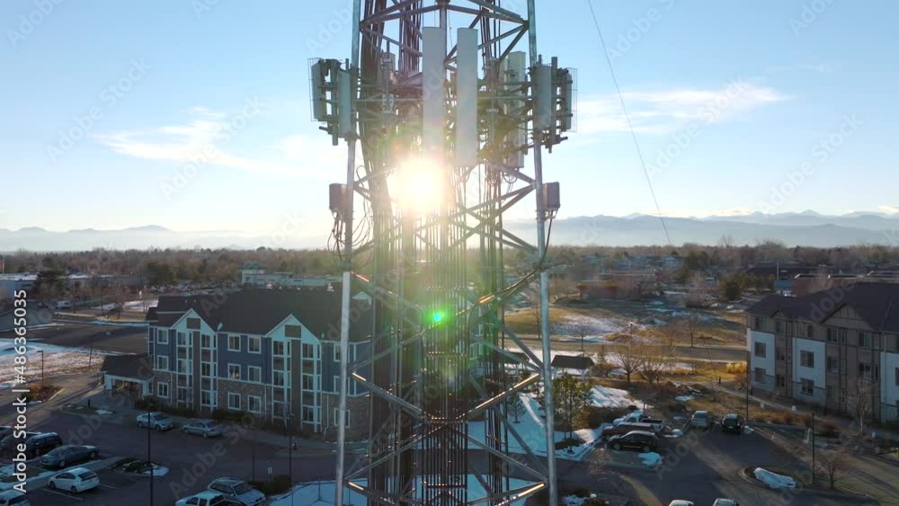 Aerial video of cell tower. Close up view backlit by sun with drone ...