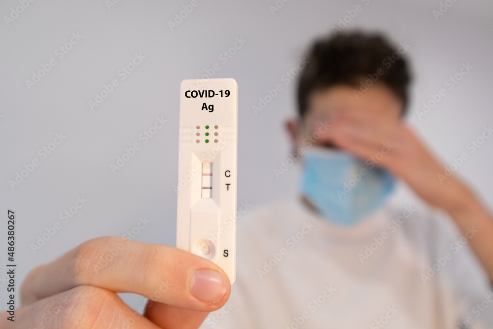 Foto de Sad and shamed man showing a positive COVID-19 Antigen test do ...