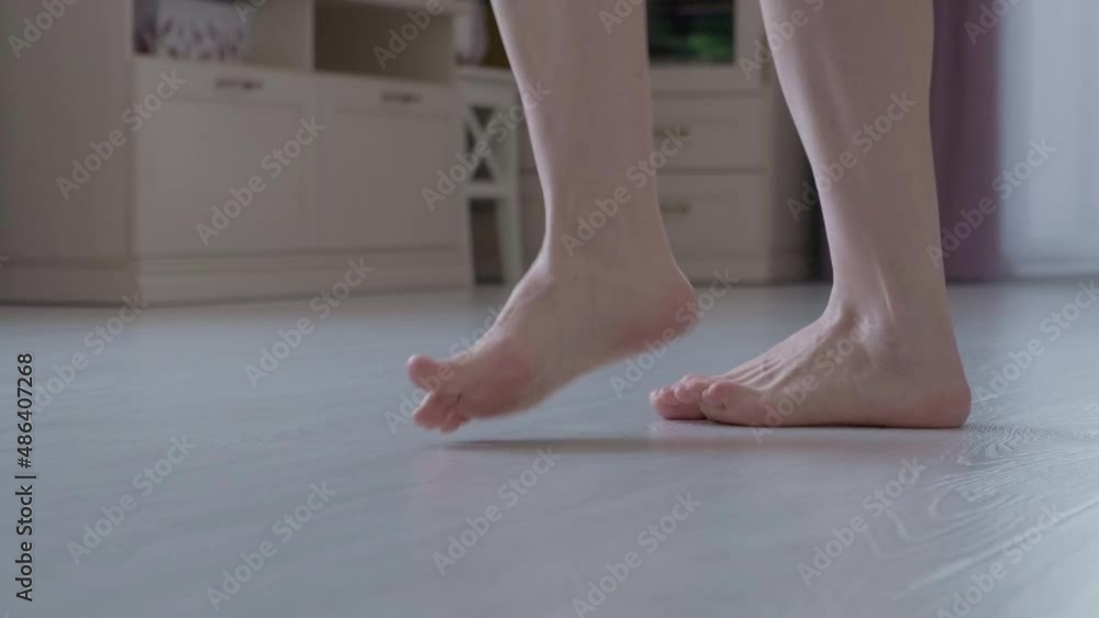 Bare female feet rise on tiptoes and spin in funny dance. Close-up ...