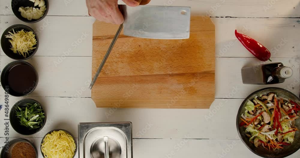 Chef's hands sharpen a large knife at the white table on working with ...