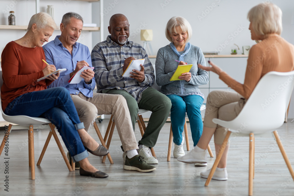 Multiracial group of elderly men and women having educational class ...