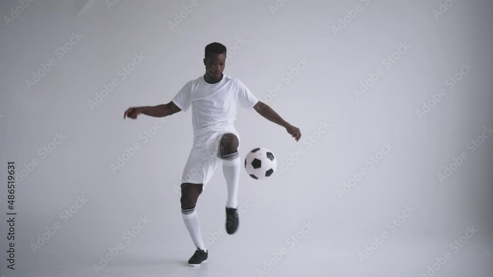 A professional black football player in a white uniform on a white ...