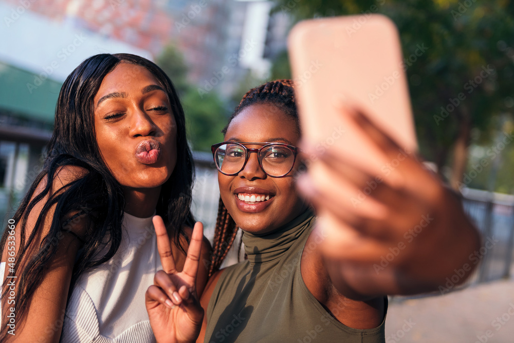 two funny young black women taking a selfie Stock Photo | Adobe Stock