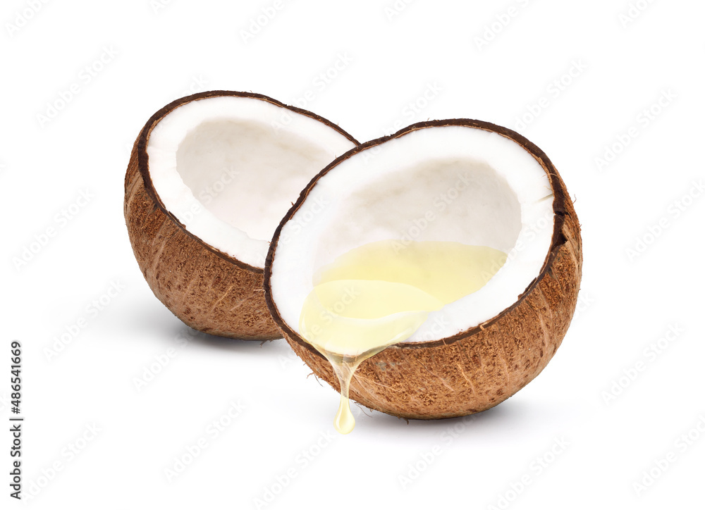 Coconut oil dripping from coconut fruits cut in half isolated on white ...