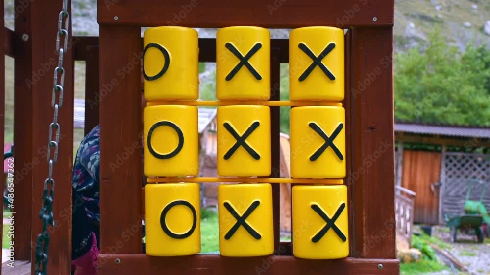 Tic Tac Toe game on playground equipment in the park. girl plays tic ...