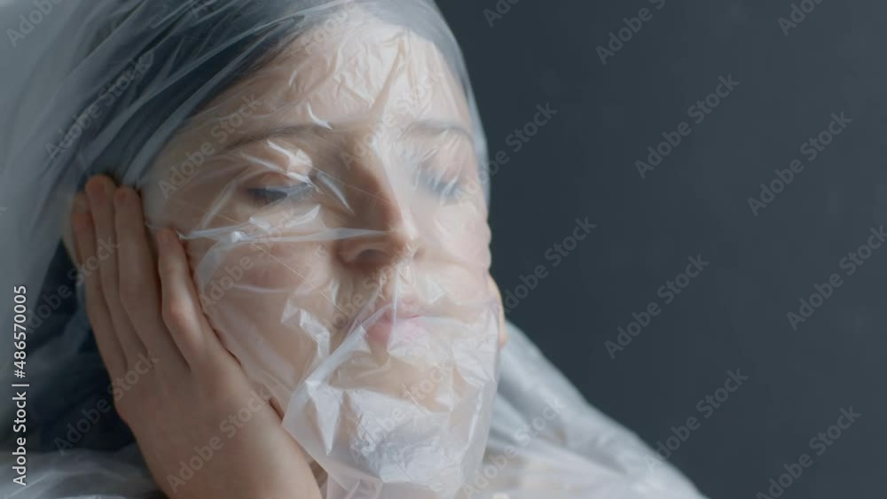 A blonde teen girl breathes through polyethylene and suffocates, cannot ...