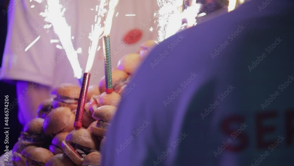 Service workers carry tray with pile of hamburgers with sparkling ...