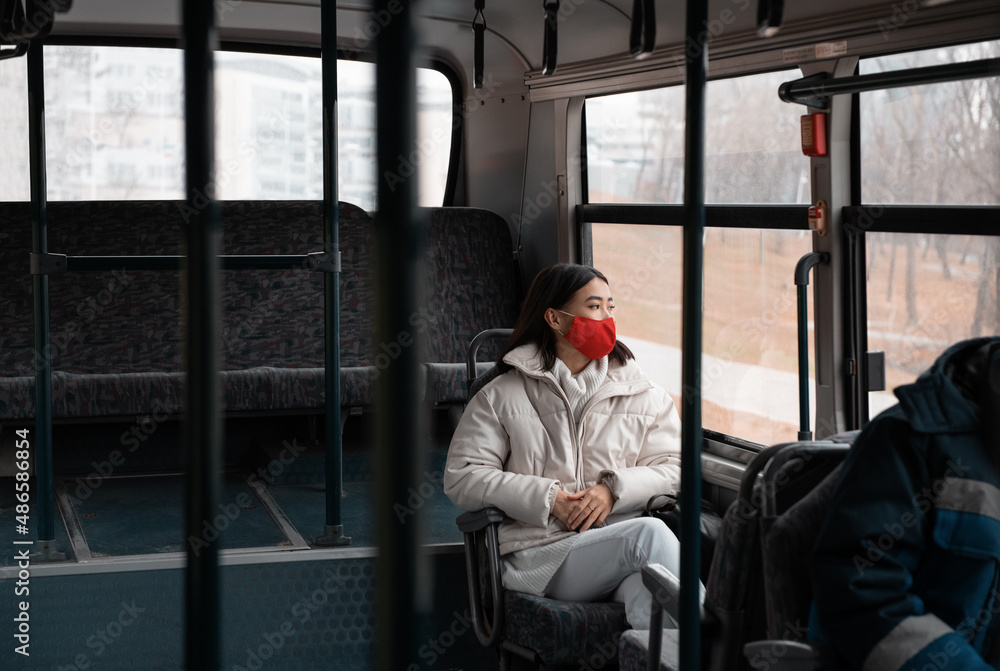 Asian female passenger looking in window of bus Stock Photo | Adobe Stock