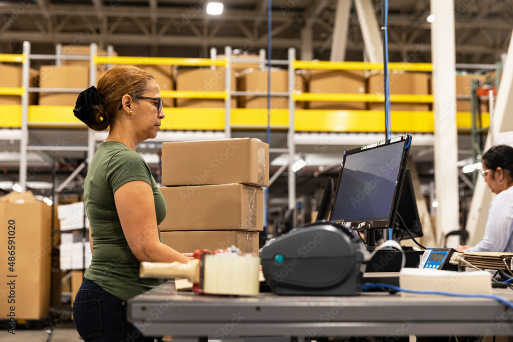 Employee enters data in computer at warehouse workstation Stock Photo ...
