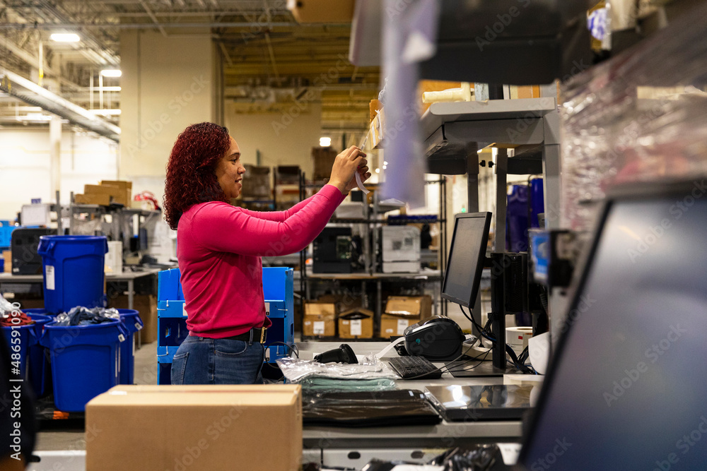 Worker packing parcel box at workstation Stock Photo | Adobe Stock