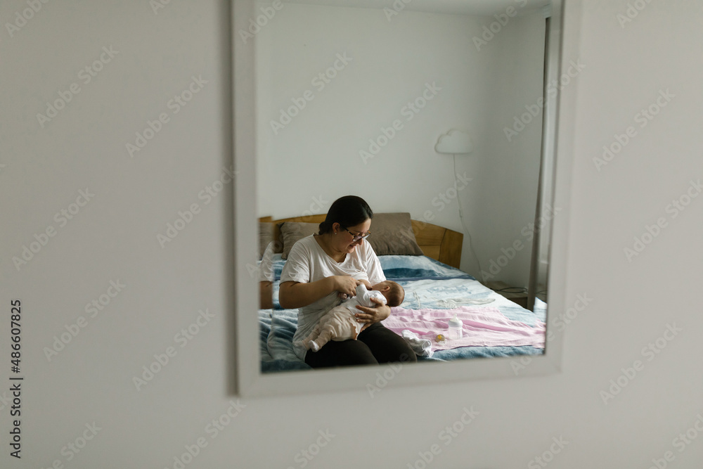 Reflection in a mirror of mom breastfeeding baby Stock Photo | Adobe Stock
