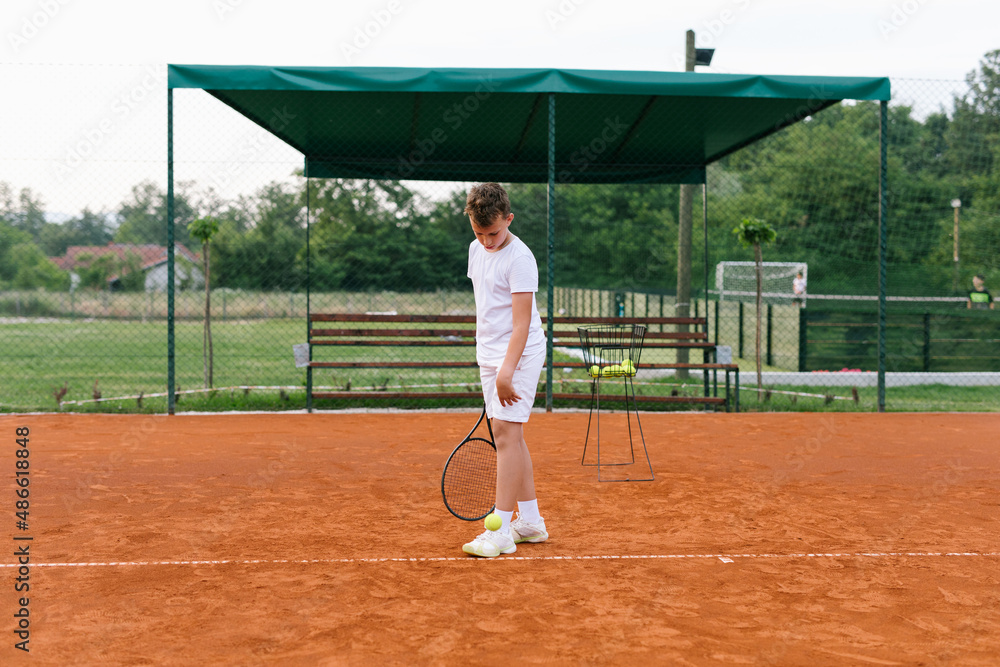 Child on a tennis court practicing tennis Stock Photo | Adobe Stock