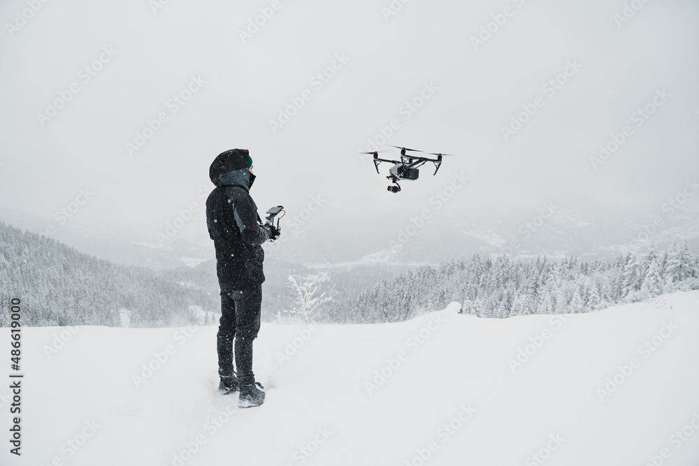 Drone pilot filming on snowy mountain Stock Photo | Adobe Stock