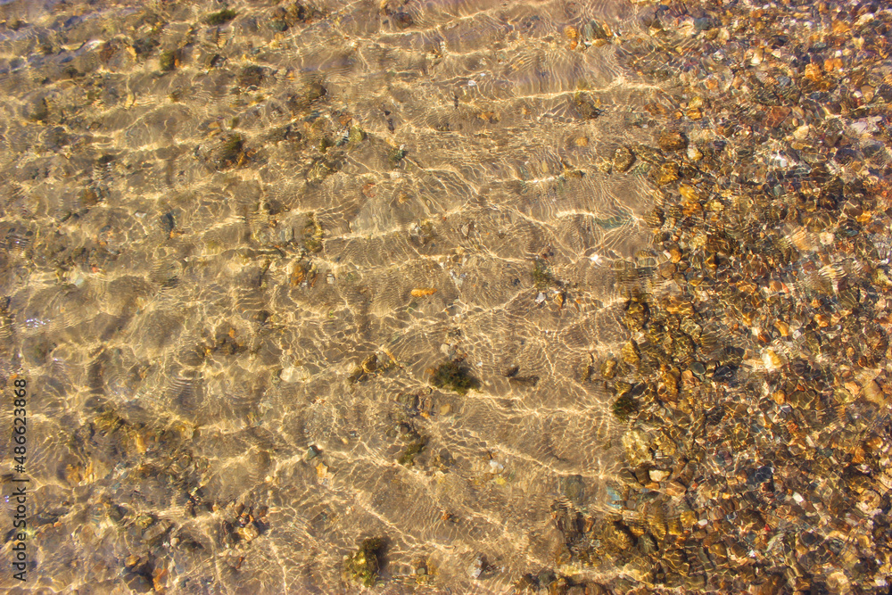 Clean sea water and stones at the bottom. Rocky seashore. Pebbles and ...
