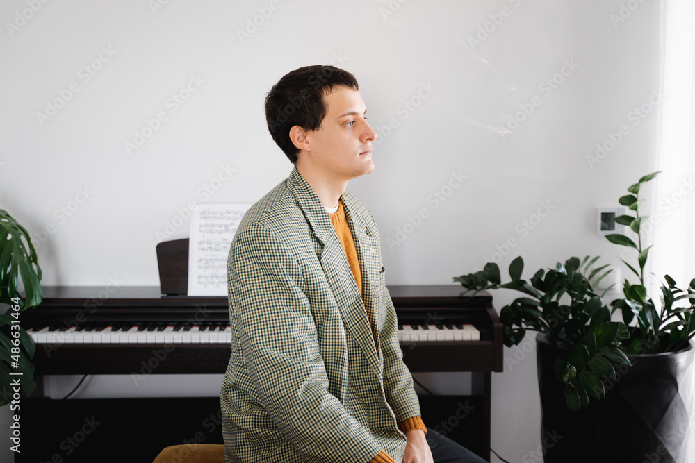 Musician Sitting By Piano Stock Photo | Adobe Stock