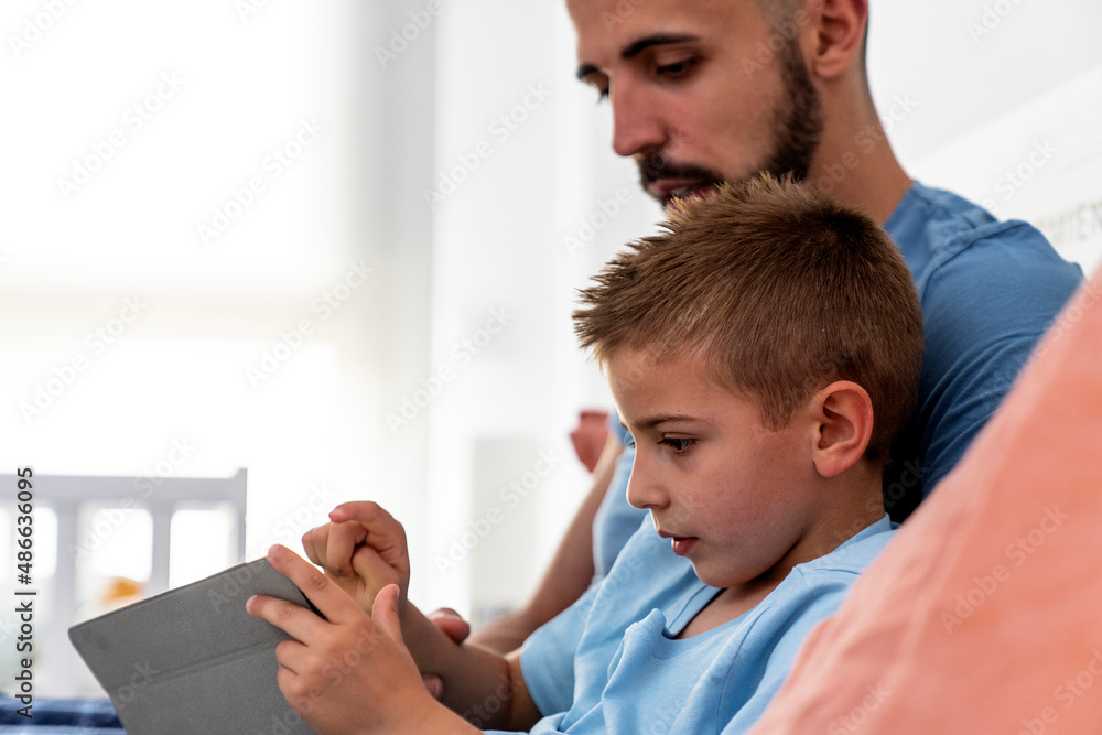 father teaching his son how to use a tablet Stock Photo | Adobe Stock