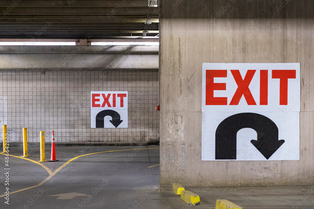 Exit Sign on concrete wall In parking Garage Stock Photo | Adobe Stock