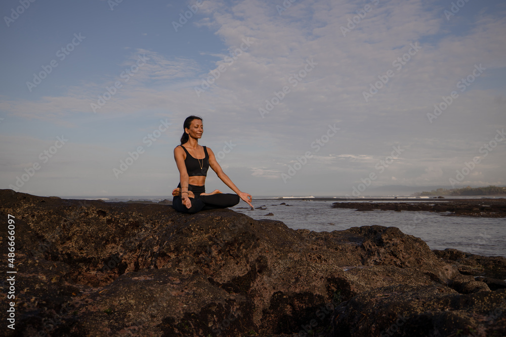 Meditation yoga on the beach. Asian woman sitting on the rock in Lotus ...
