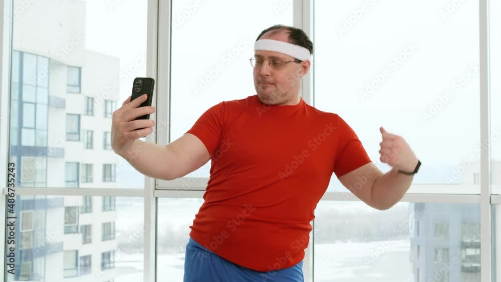 Funny fat man with big belly posing and doing selfie in bright gym or ...