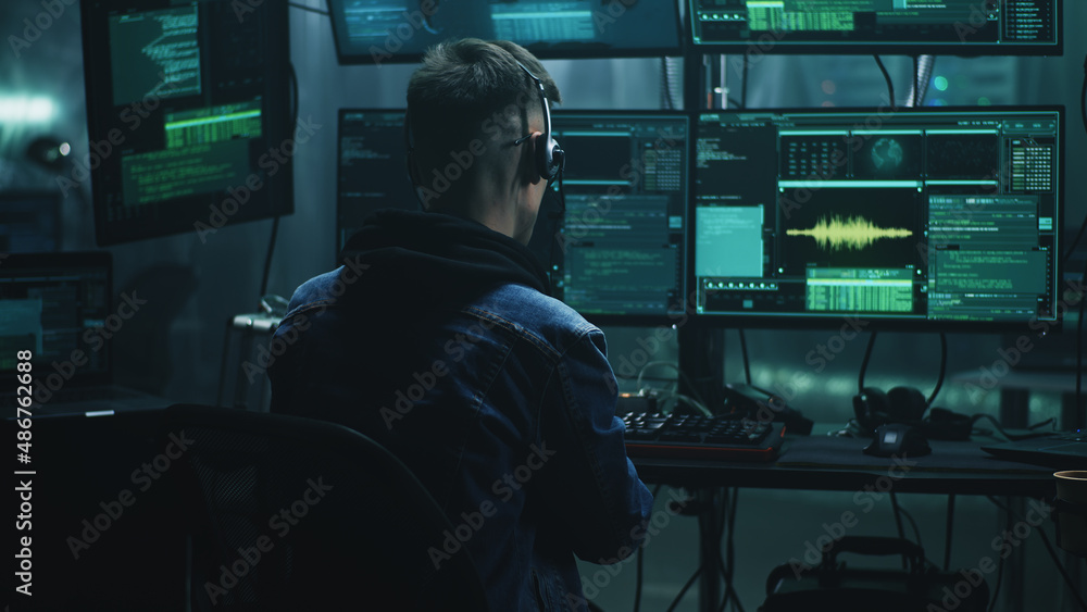 Cheerful male hacker in headset rejoicing in a successful cyber attack ...