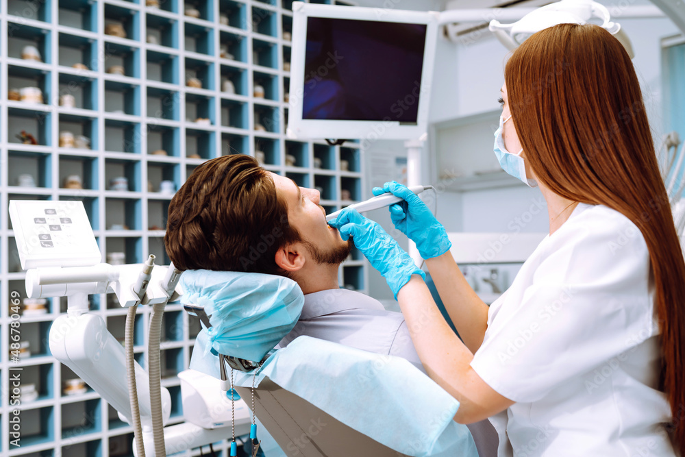 Man having a visit at the dentist's. Handsome patient sitting on chair ...