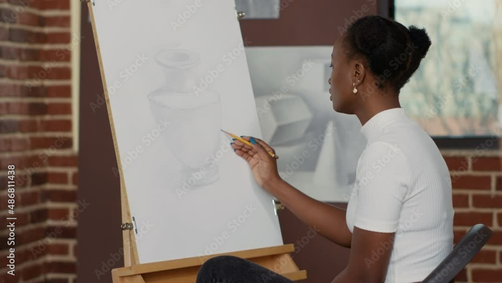 Art class student using pencil to outline vase sketch on canvas ...