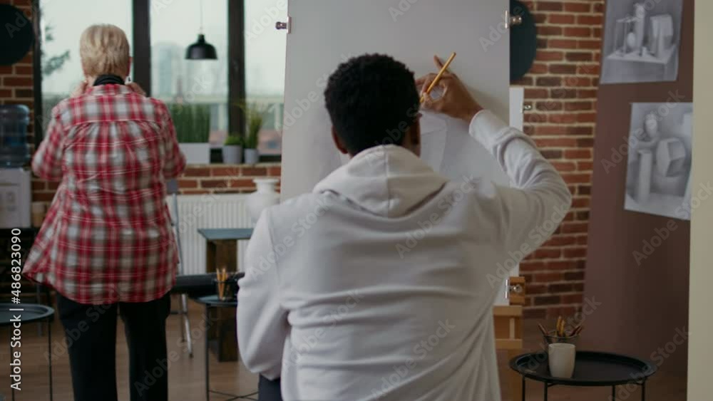 Diverse group of students attending art class lesson in studio, drawing ...
