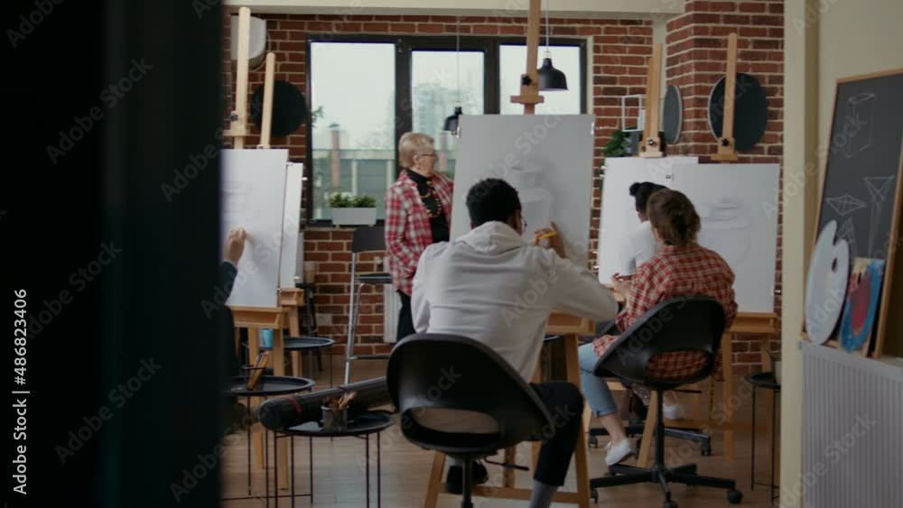 Diverse group of people attending drawing lesson in art class, using ...