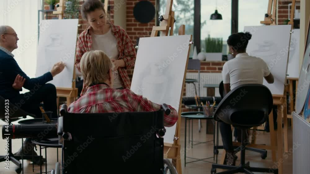 Elder woman with disability attending art class lesson with young ...