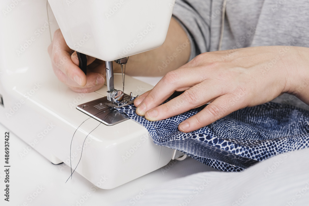Tailor sews clothes on an electric sewing machine Stock Photo | Adobe Stock